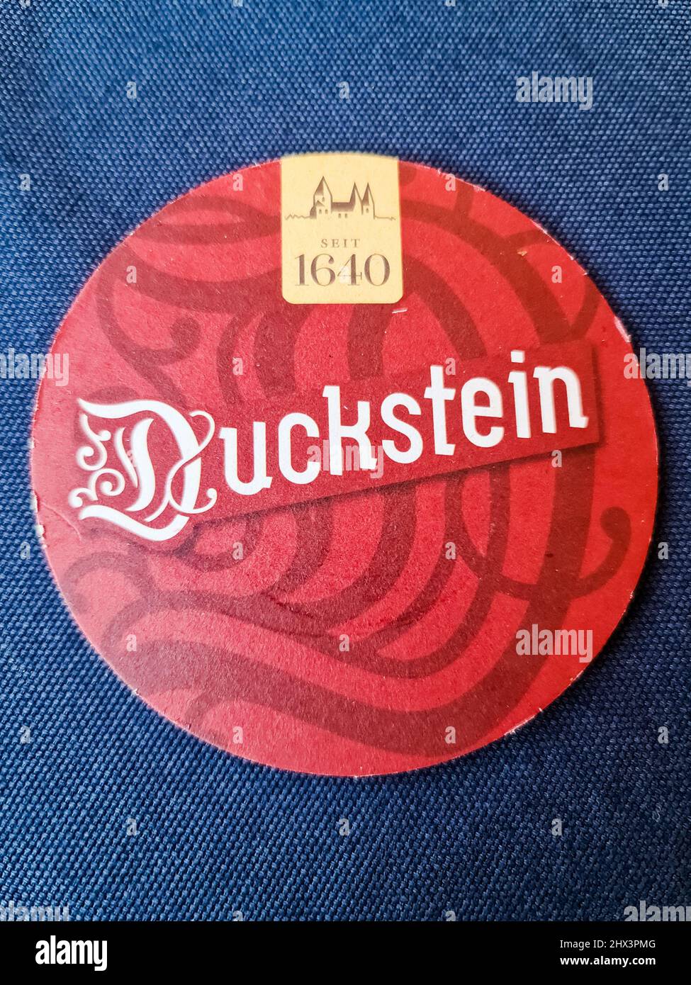 A red Duckstein brand coaster on a blue table - top view Stock Photo ...