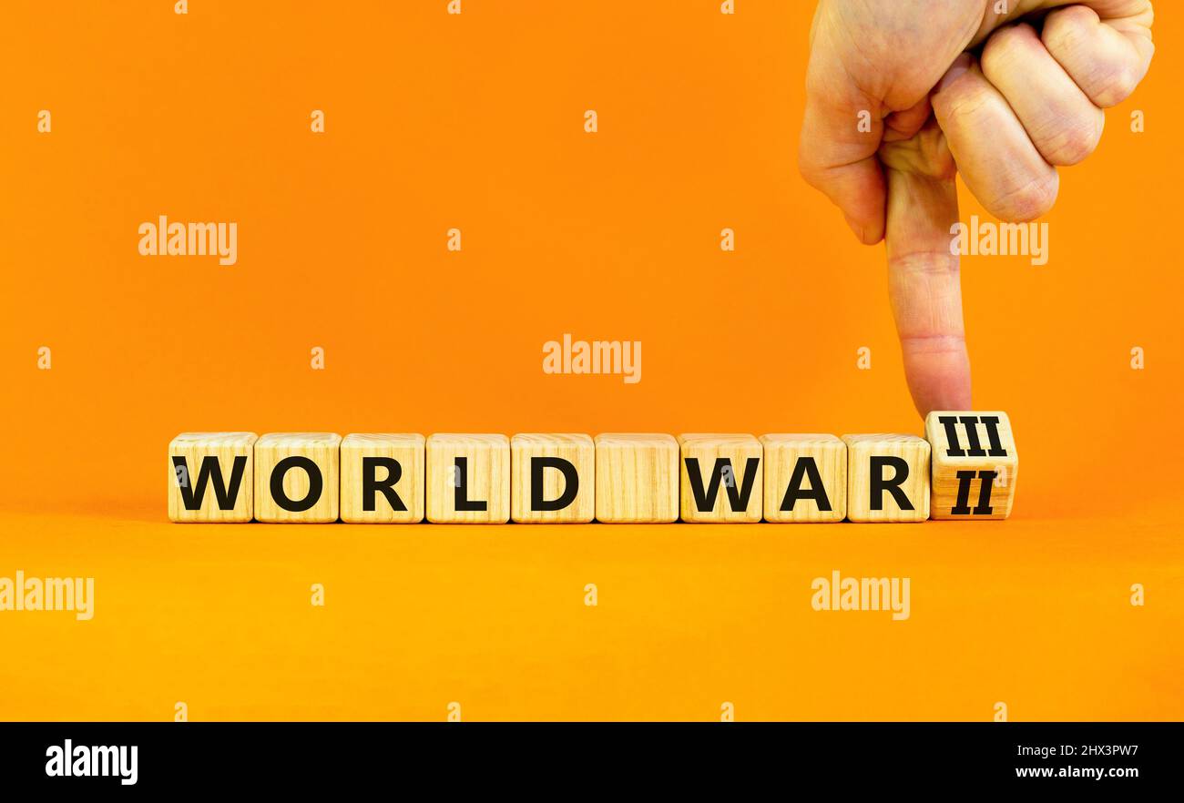 WW3 world war 3 symbol. Businessman turns the wooden cube and changes ...