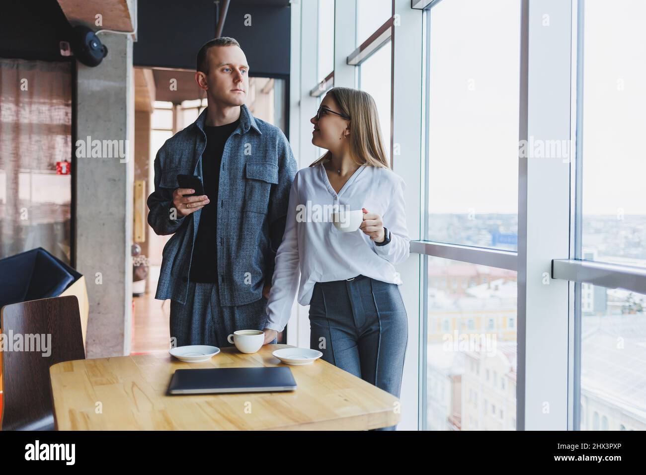 Smart young professionals in casual clothes checking data on the phone ...