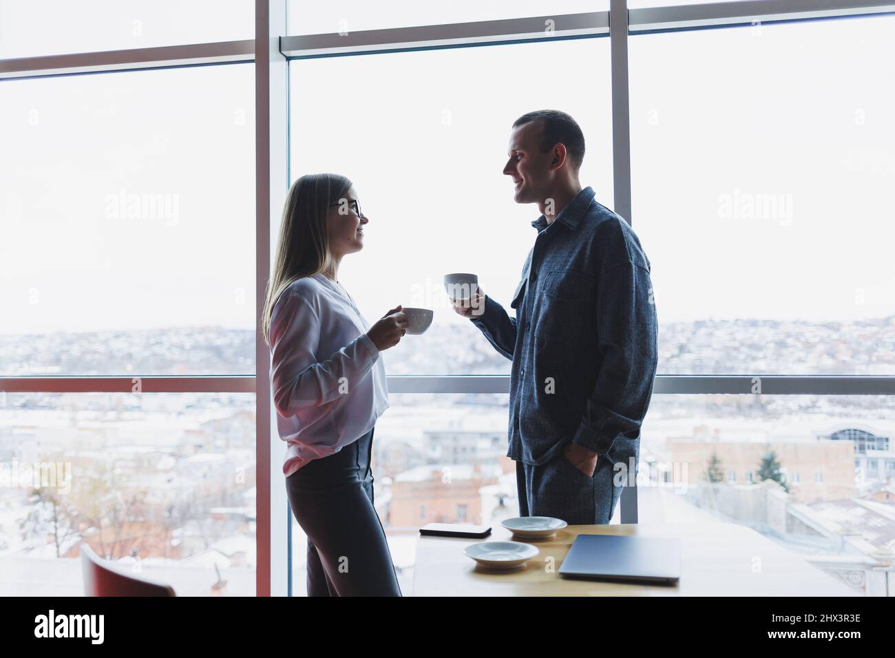 Handsome male businessman and young business woman are standing and ...