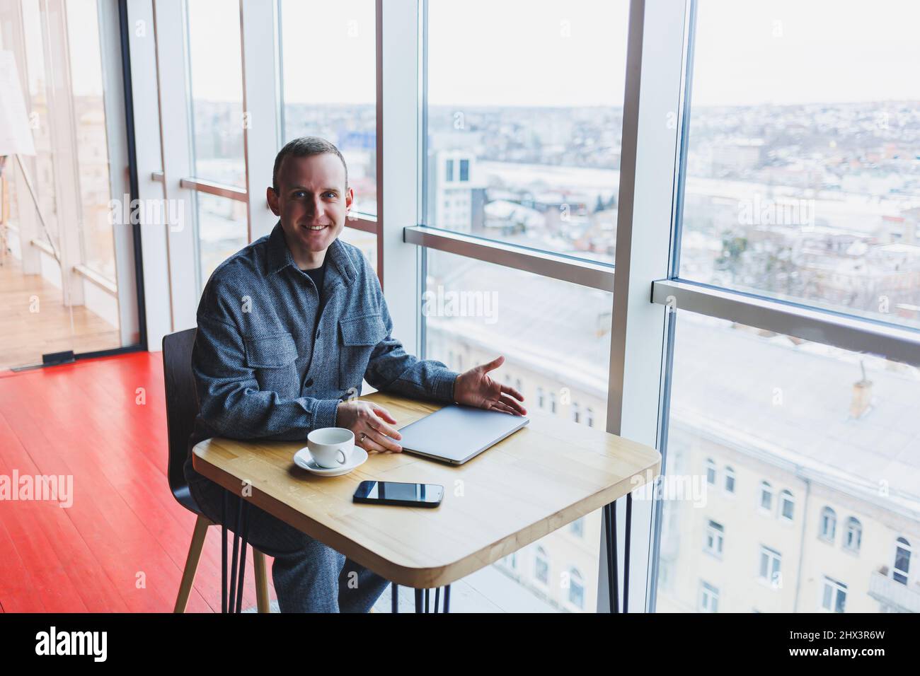 Happy man with coffee calling via smartphone while remote working ...