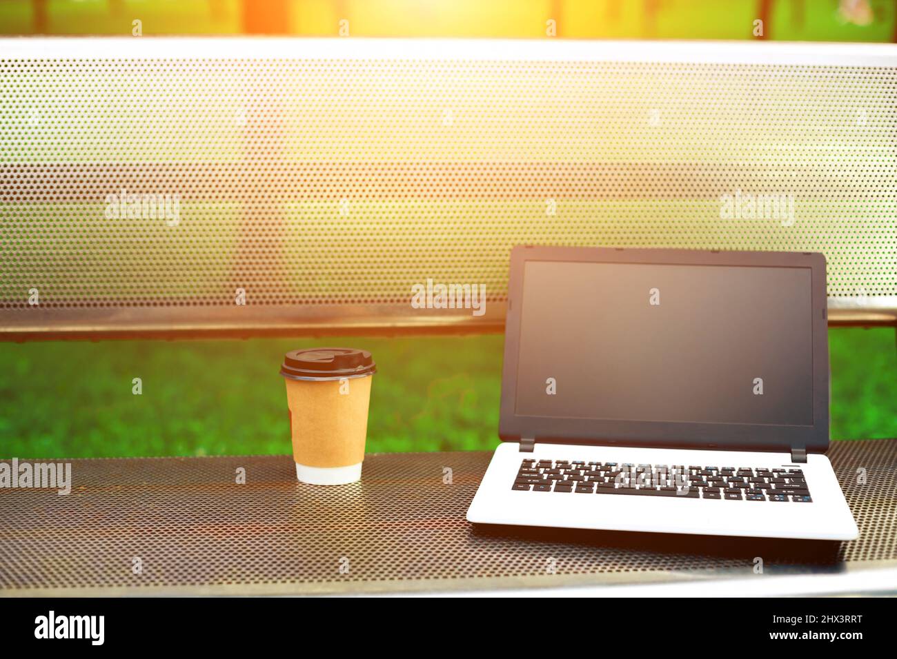 Mockup image of laptop with blank black screen and coffee cup on metal ...