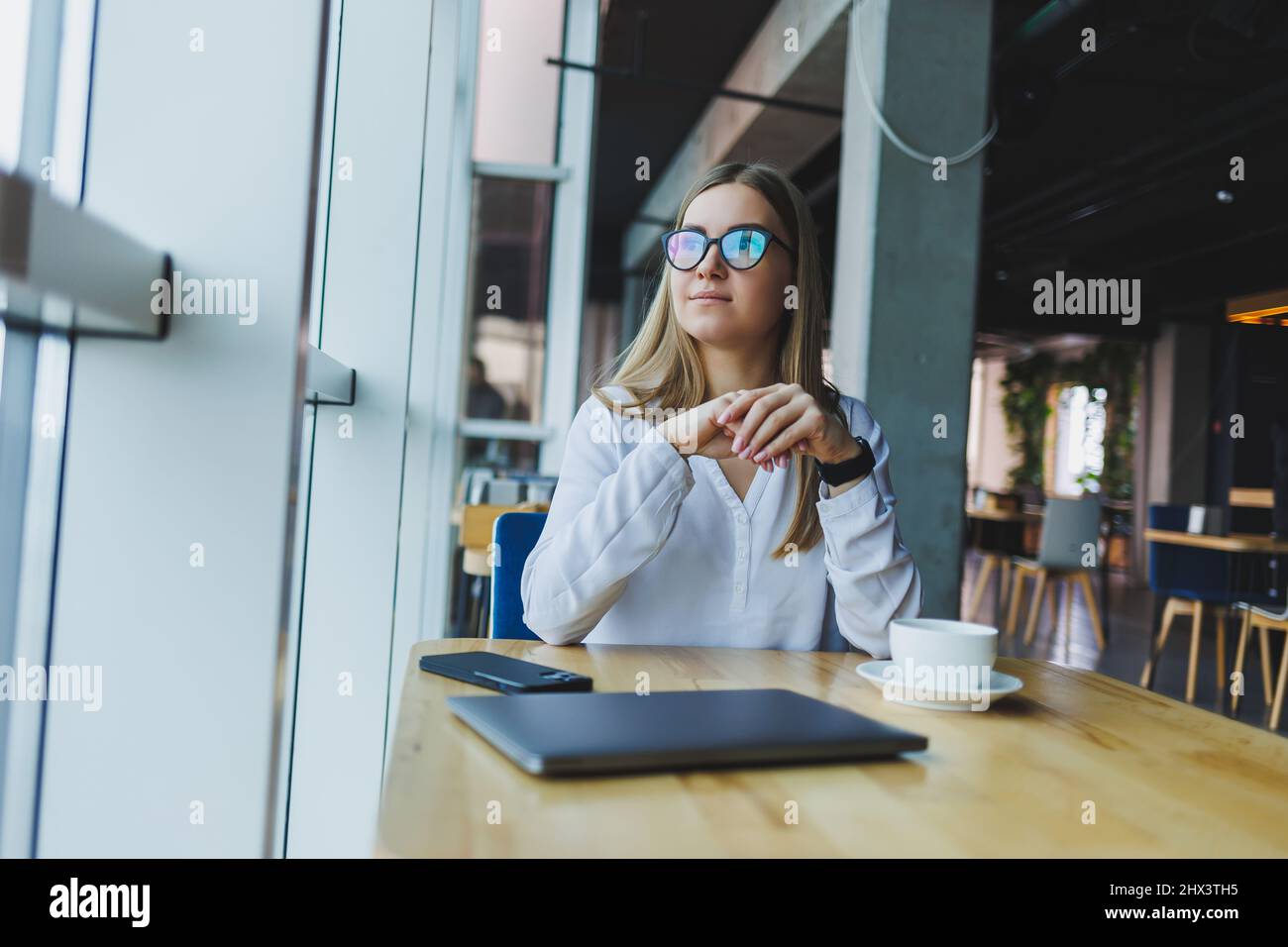 Pretty European young business woman in a coffee shop. Wearing an ... Pretty European young business woman in a coffee shop. Wearing an ...