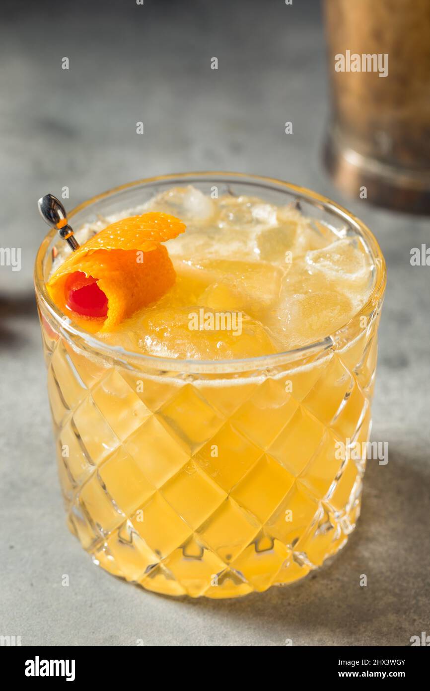 Cold Boozy Rye Whiskey Sour with Lemon and a Garnish Stock Photo - Alamy