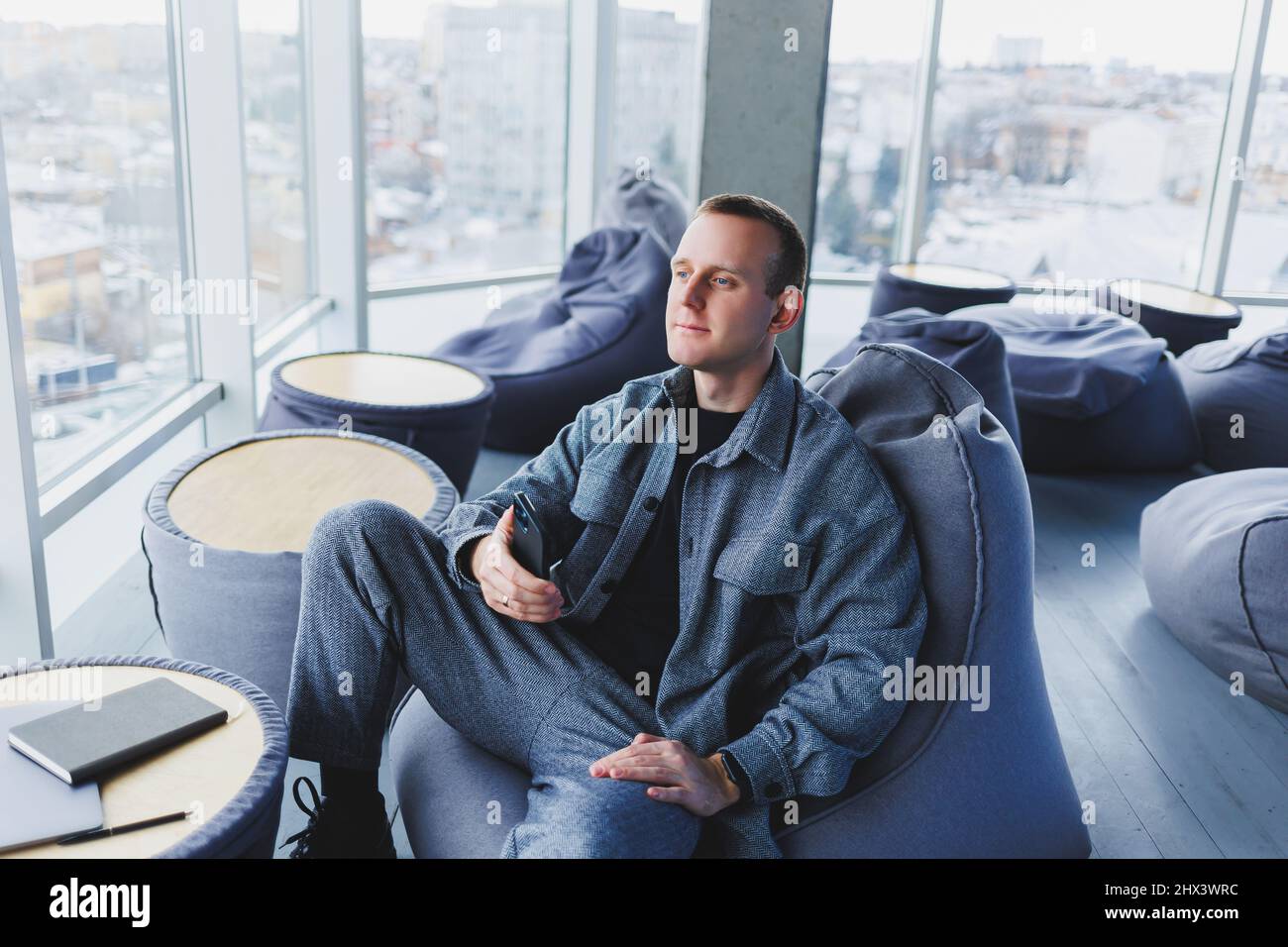 Confident male manager sitting in a modern workspace at a laptop and ...