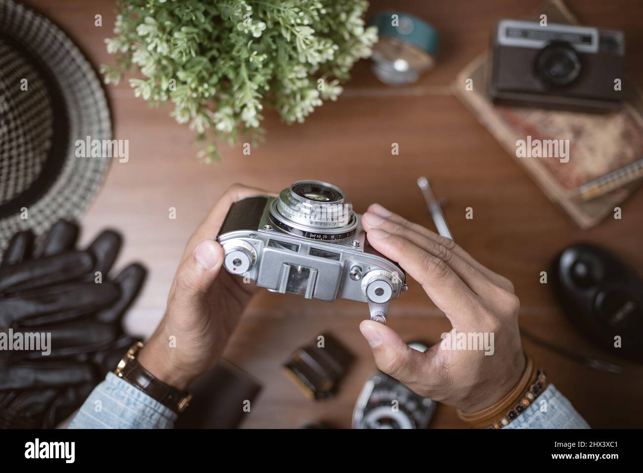 Photographer holding vintage camera in his hand over the desktop Stock ...