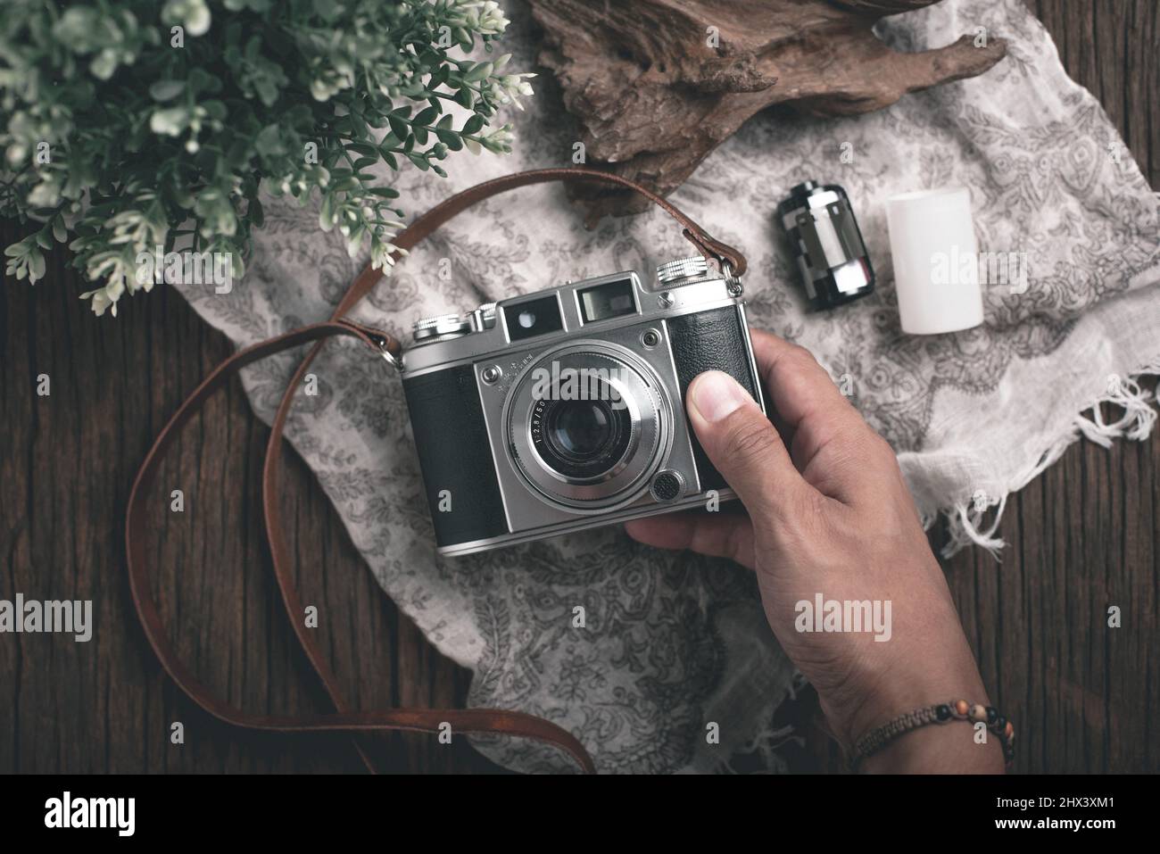 Photographer holding vintage camera in his hand over the desktop Stock ...