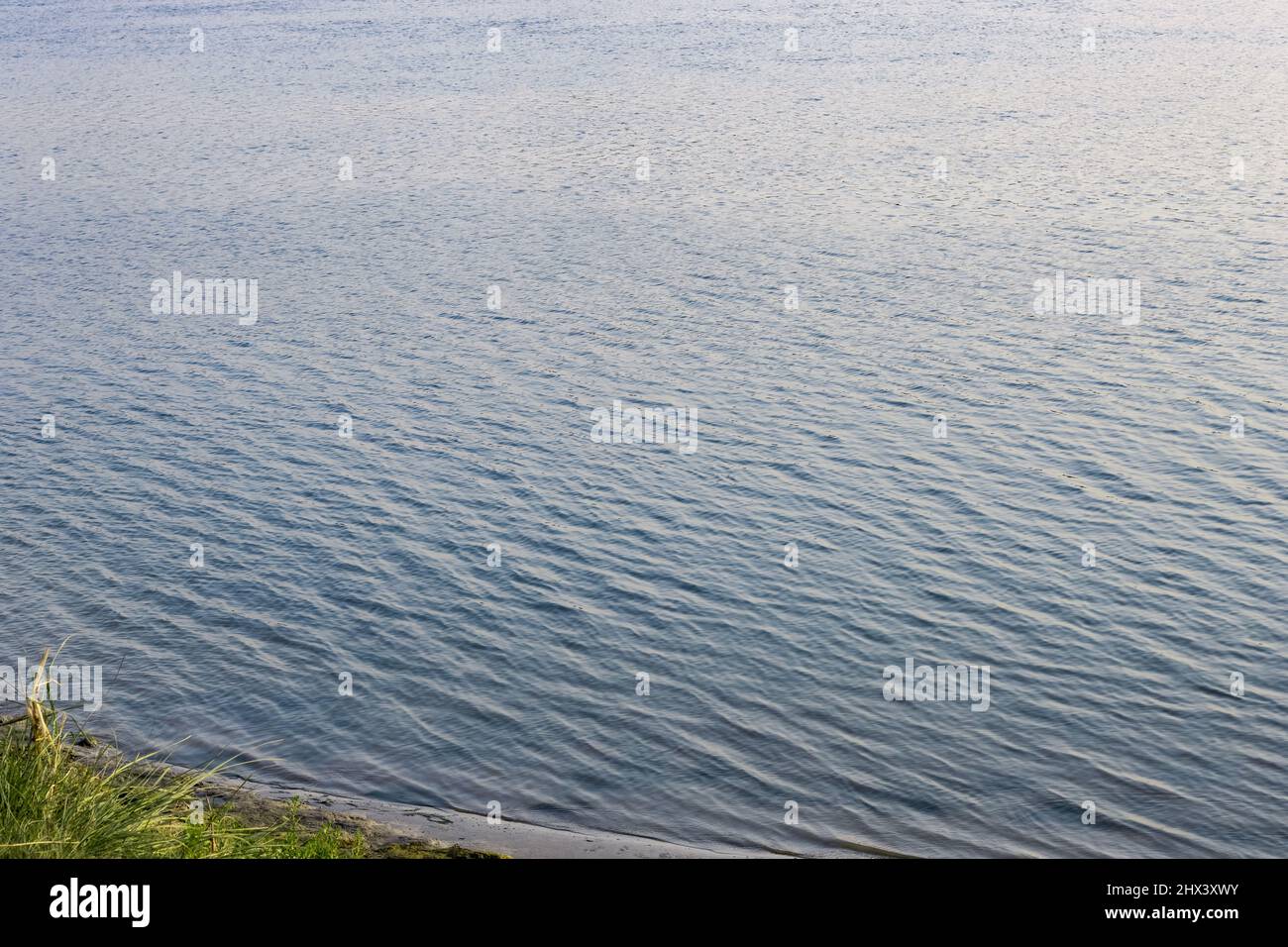 Beautiful riverbank in the evening with calm blue water Stock Photo - Alamy