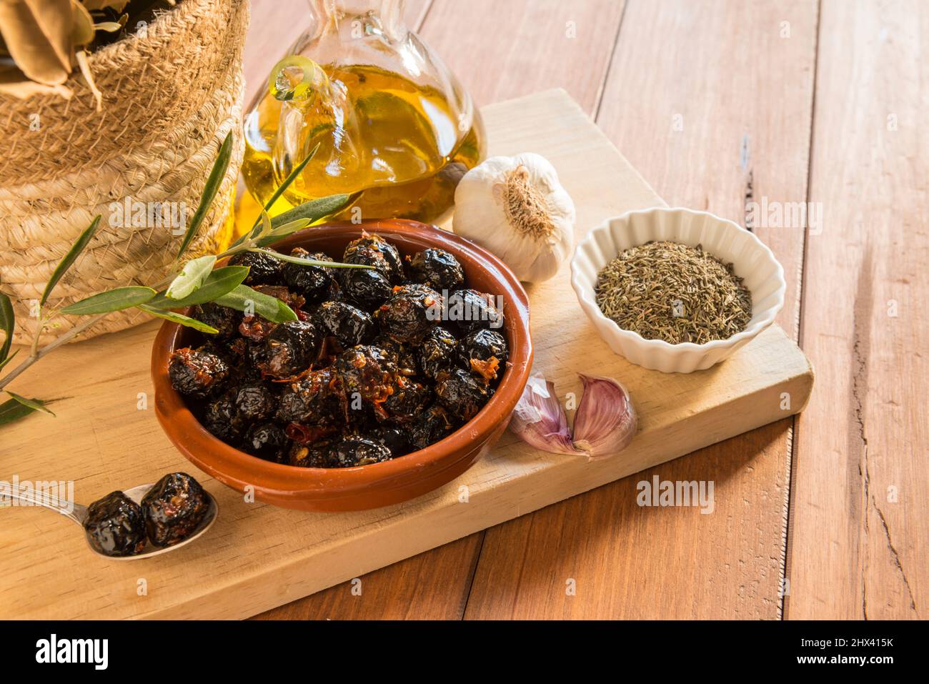 Still life with a bowl of olives, together with different seasonings ...
