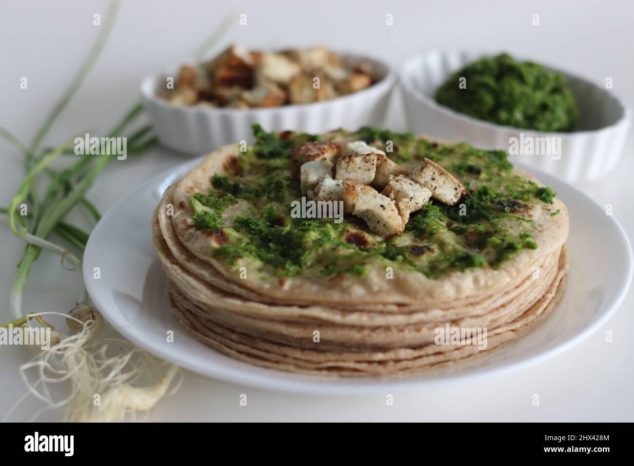 Indian flat bread smeared with green garlic condiment and served with ...