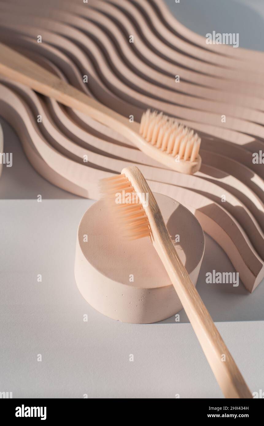 Wooden toothbrush on a round podium with shadows. Eco-friendly personal ...