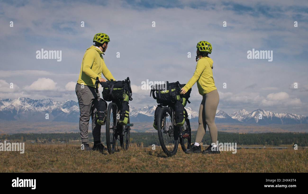 The man and woman travel on mixed terrain cycle touring with ...