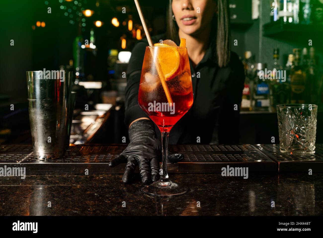 The young brunette Latina prepares a cocktail at the bar counter. job ...