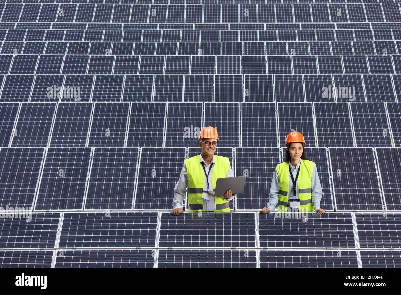 Mature male engineer and a young female engineer on a photovoltaic ...