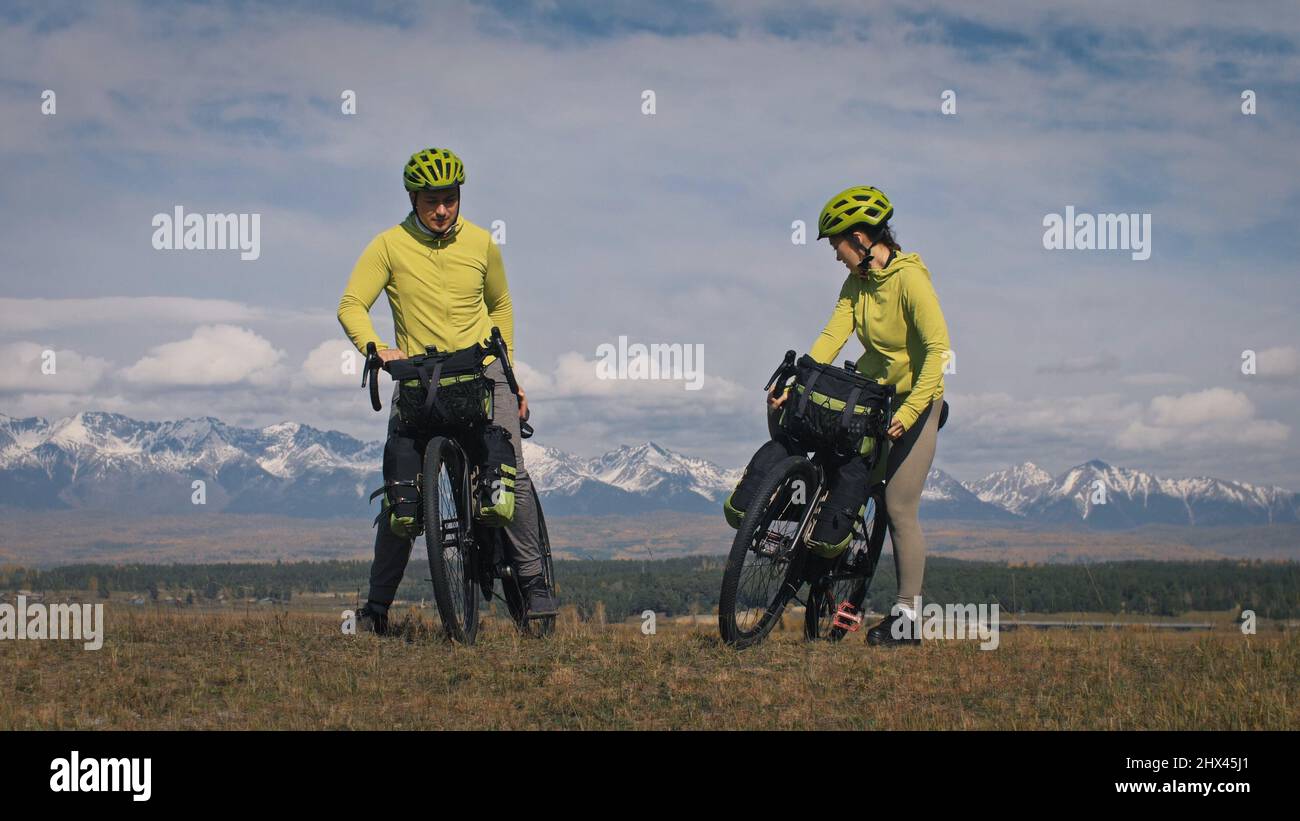 The man and woman travel on mixed terrain cycle touring with ...