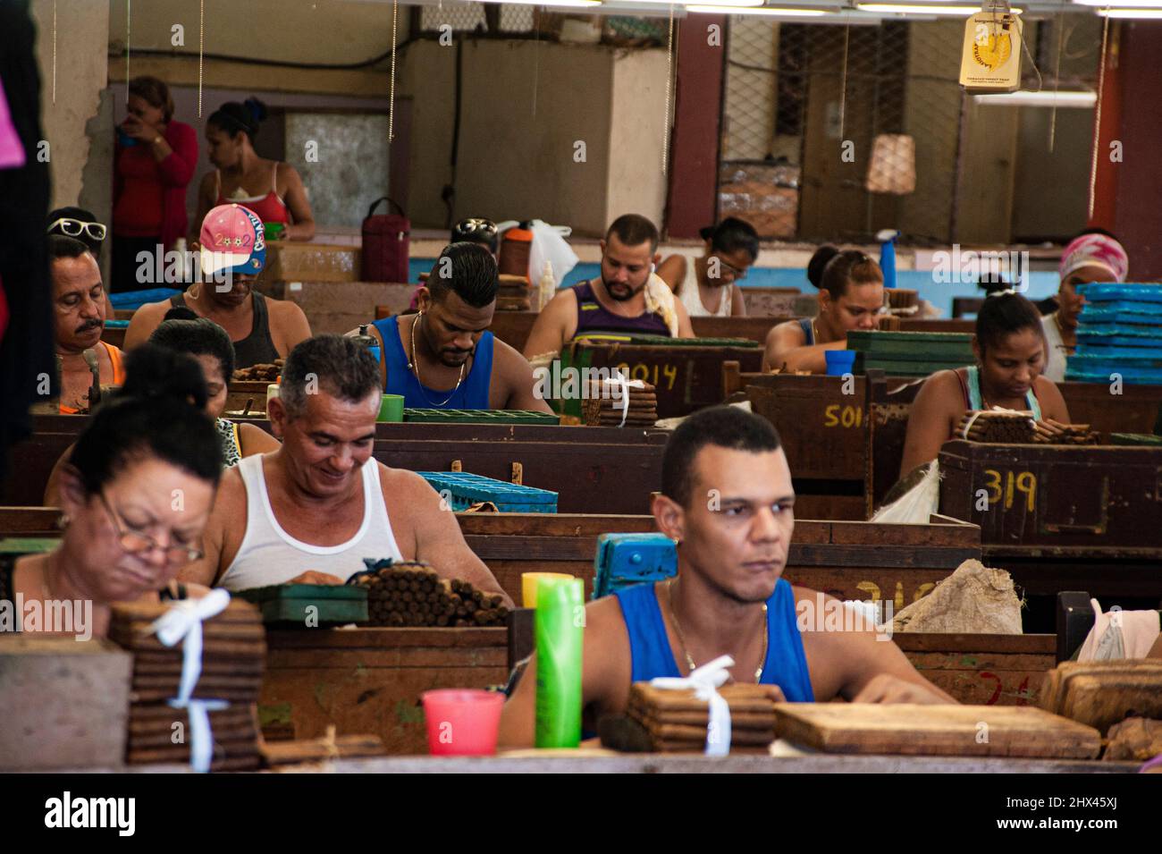 Men and woman sitting in a factory in Trinidad, Cuba working by hand on ...