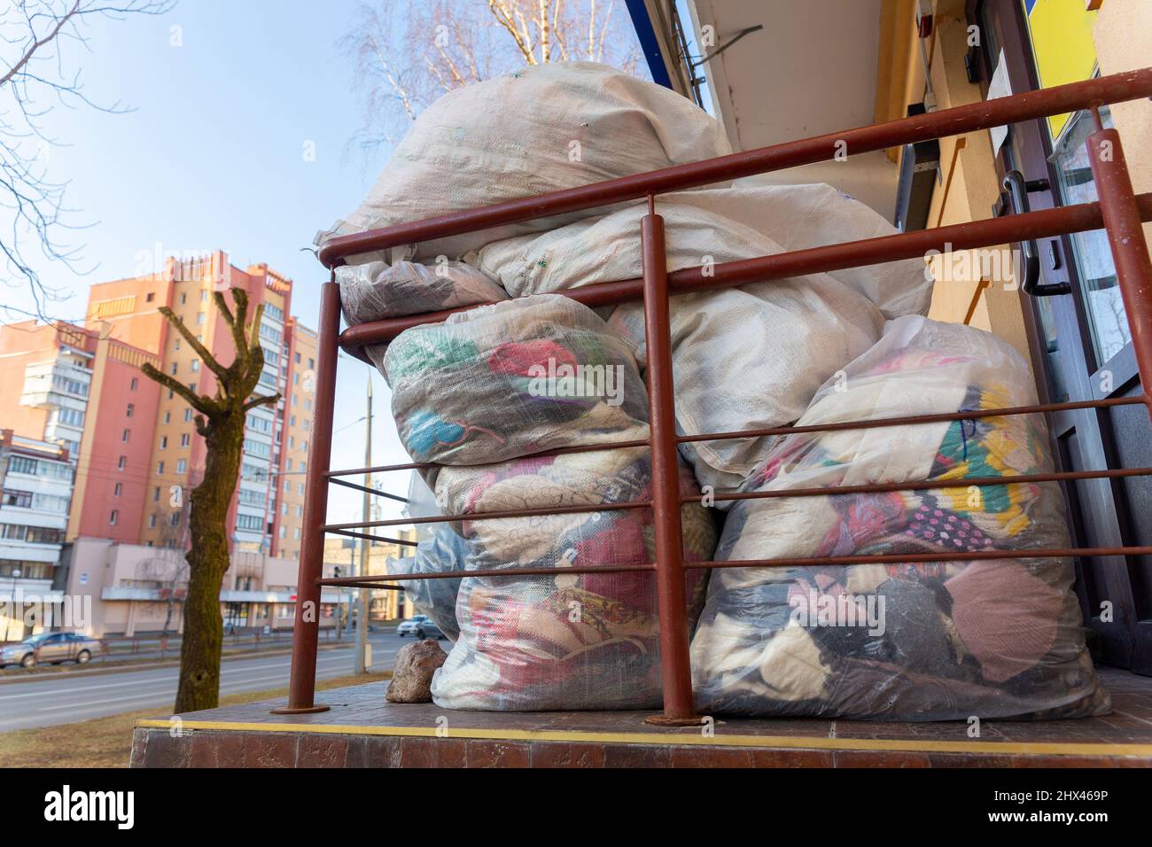 Used clothes and shoes in plastic bags. New arrival of the goods in the ...