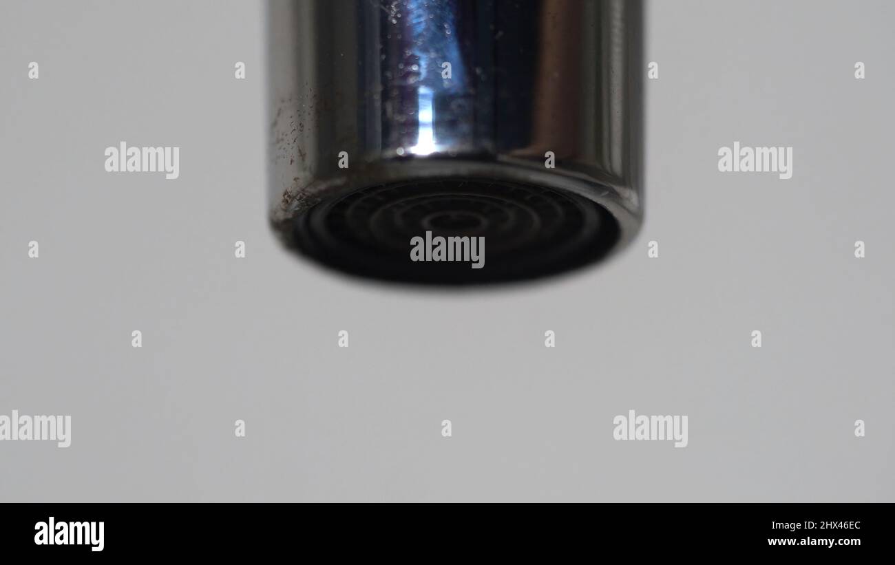 Extreme close up of the water flowing from the faucet and then stopping ...