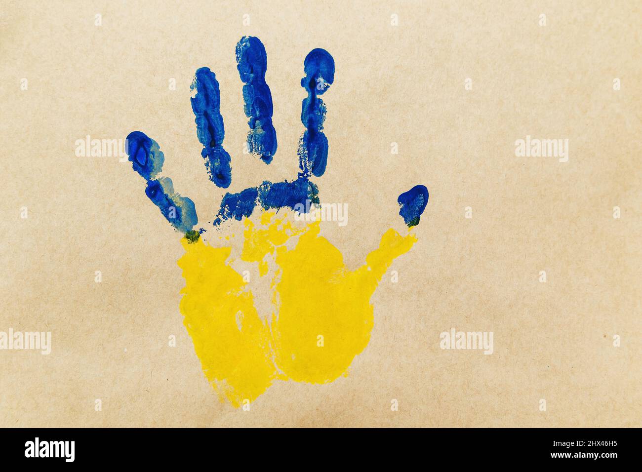 Handprint in the colors of the Ukrainian flag. Craft background, place ...