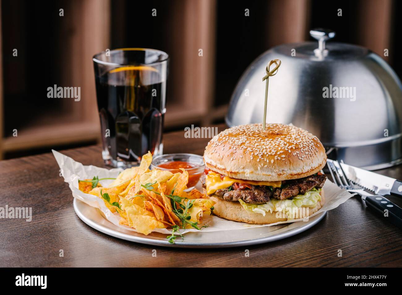 Juicy cheeseburger with potato chips and cola Stock Photo - Alamy
