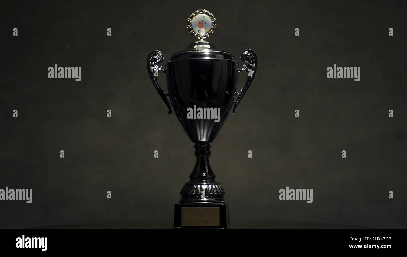 Champion golden trophy placed on wooden table with dark background copy ...