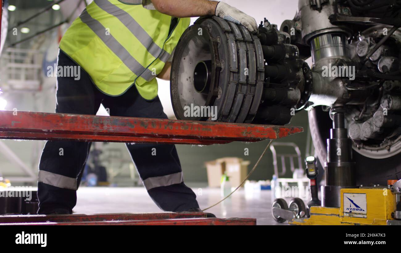 Airport worker checking chassis. Engine and chassis of the passenger ...
