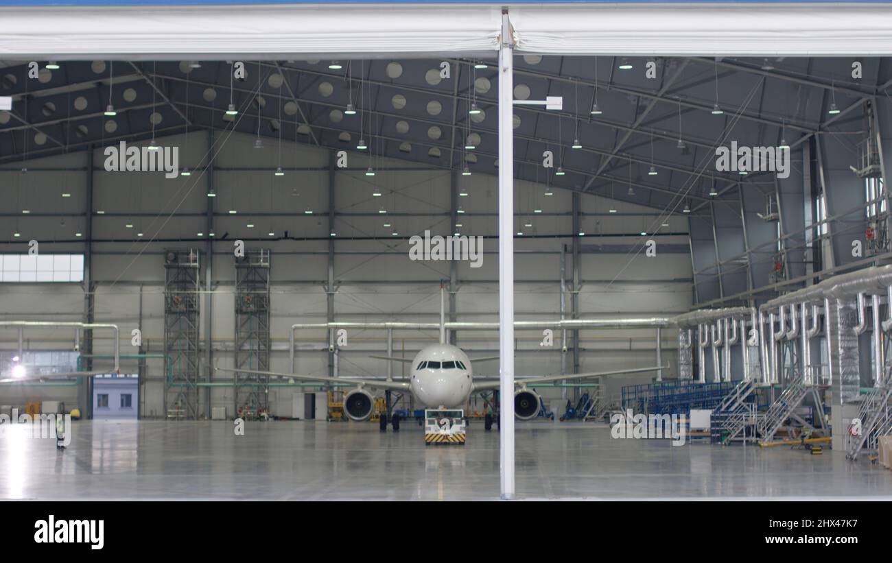 Roller shutter door and concrete floor of airport hangar and airplane ...