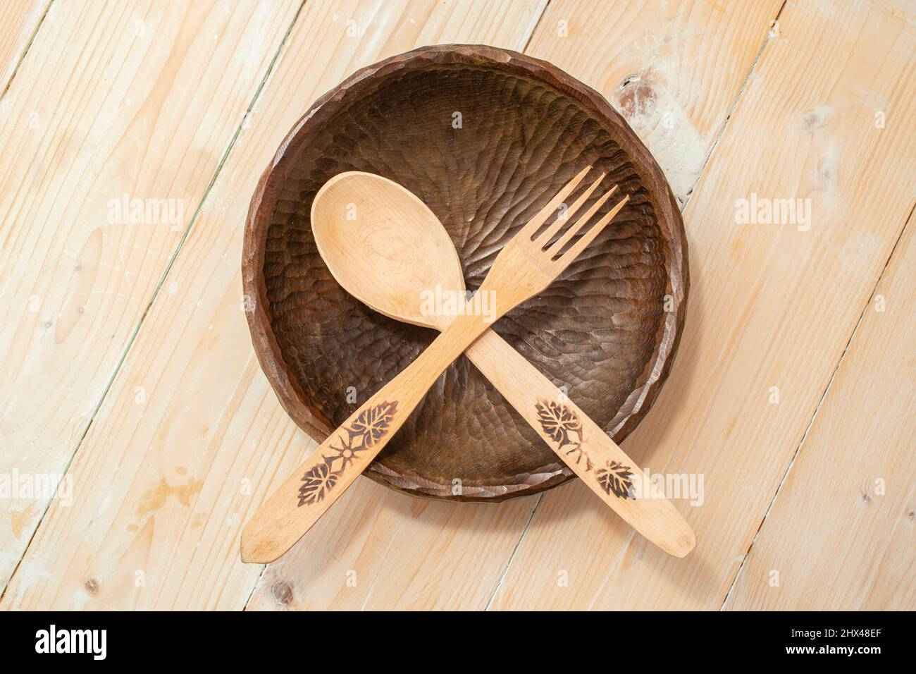 wooden sculpted plate with crossed spoon and fork, wood boards ...
