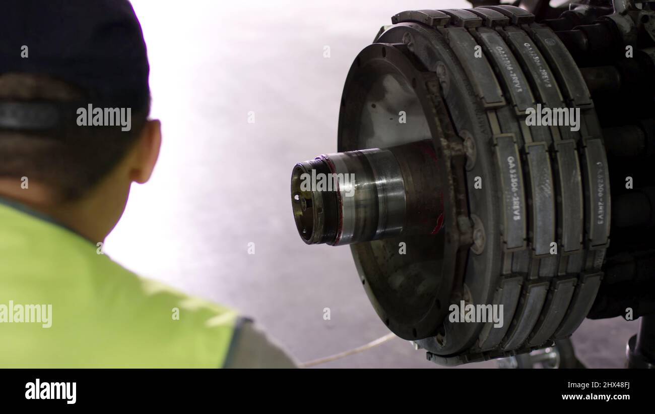 Airport worker checking chassis. Engine and chassis of the passenger ...