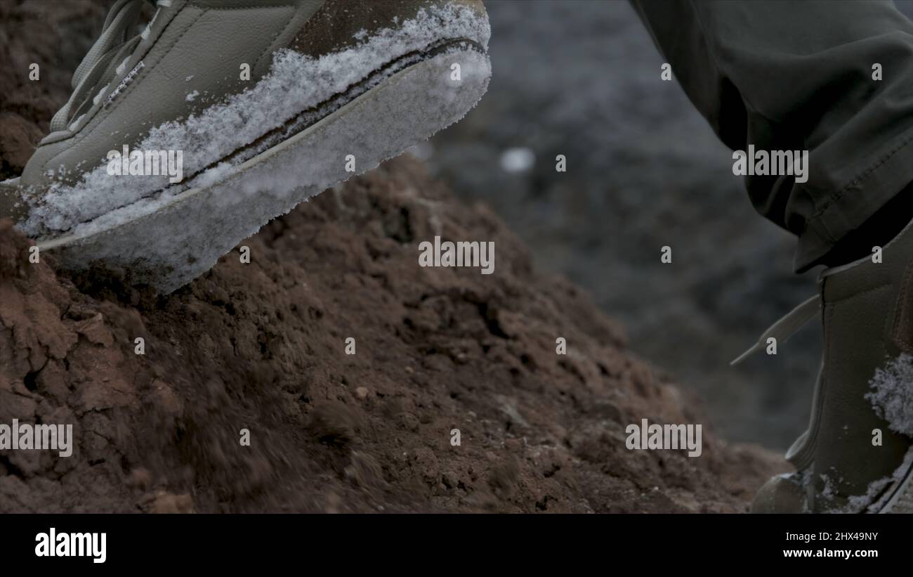 Close up of hiking boots and legs climbing up rocky trail. Close up ...