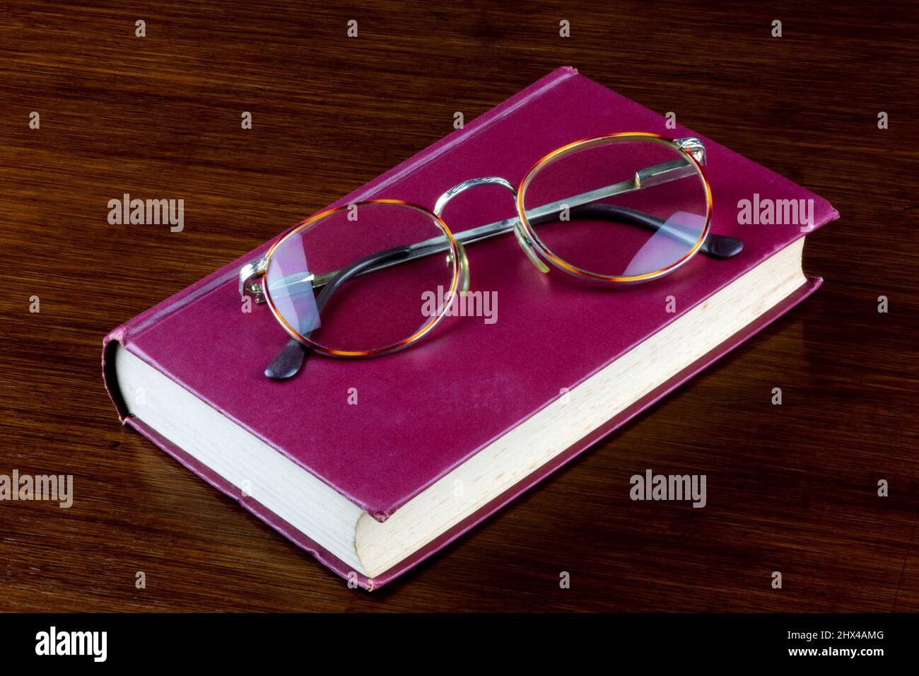 Old book and spectacles on a polished wooden surface Stock Photo - Alamy