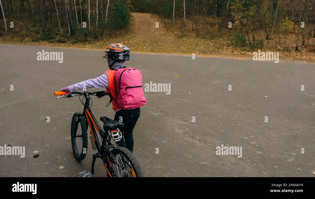 One caucasian children walk with bike in autumn park. Little girl ...