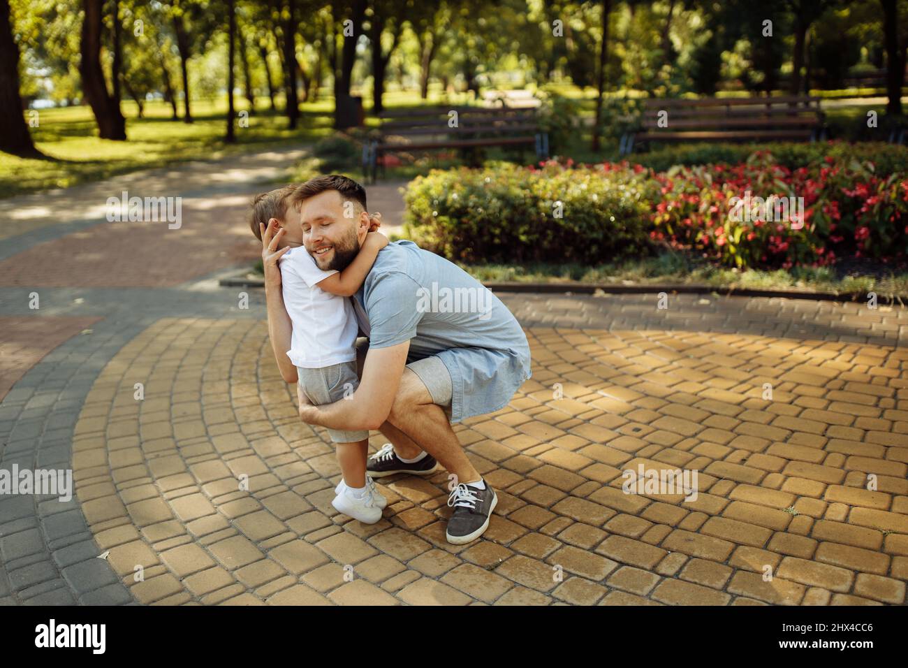 Overjoyed man with little boy at the park, lovely son hugging caring ...
