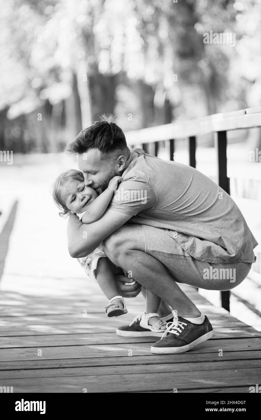 Happy father with joyful kid at the park, caring dad hug and kiss cute ...
