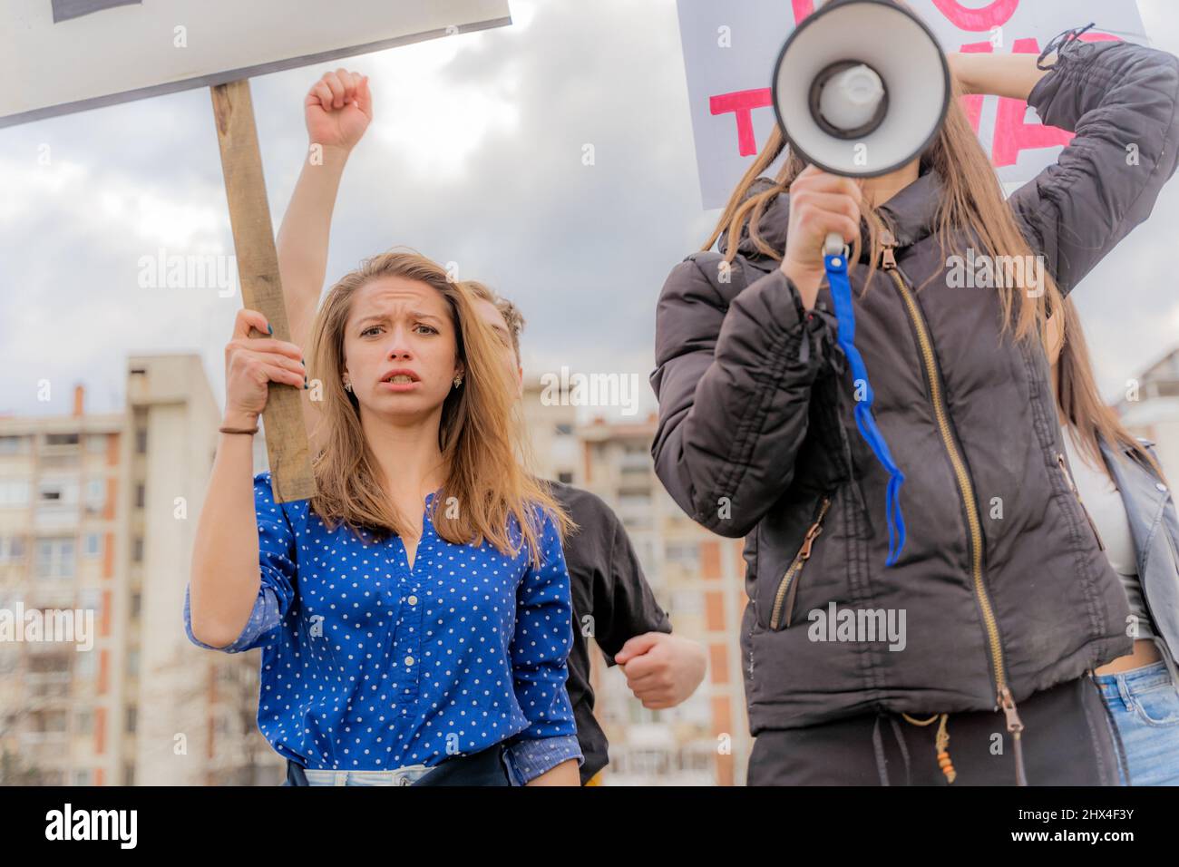 Group of young people are having a protest outside on the street while ...