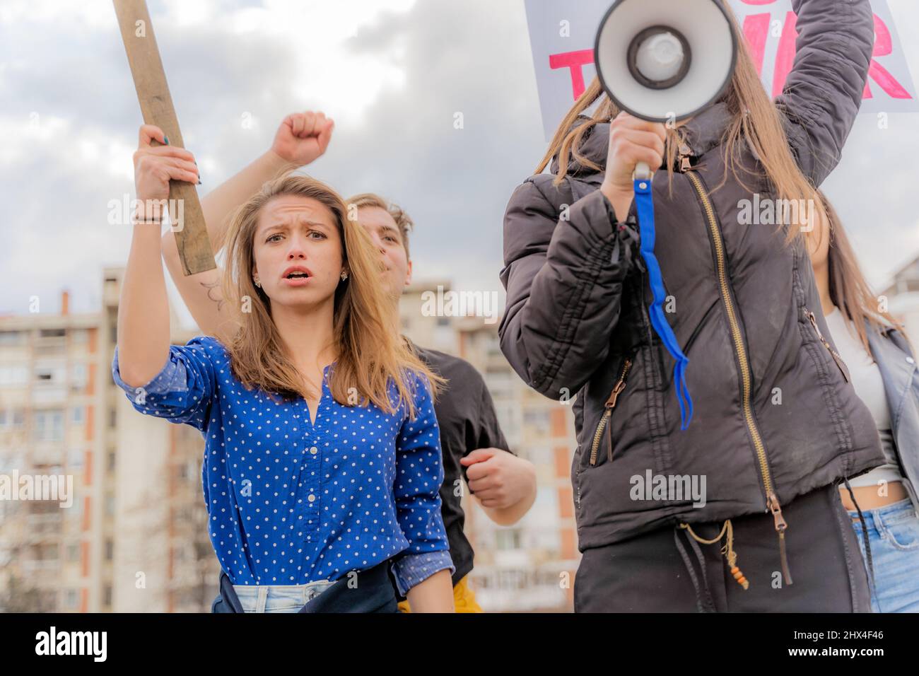 Group of young people are having a protest outside on the street, close ...