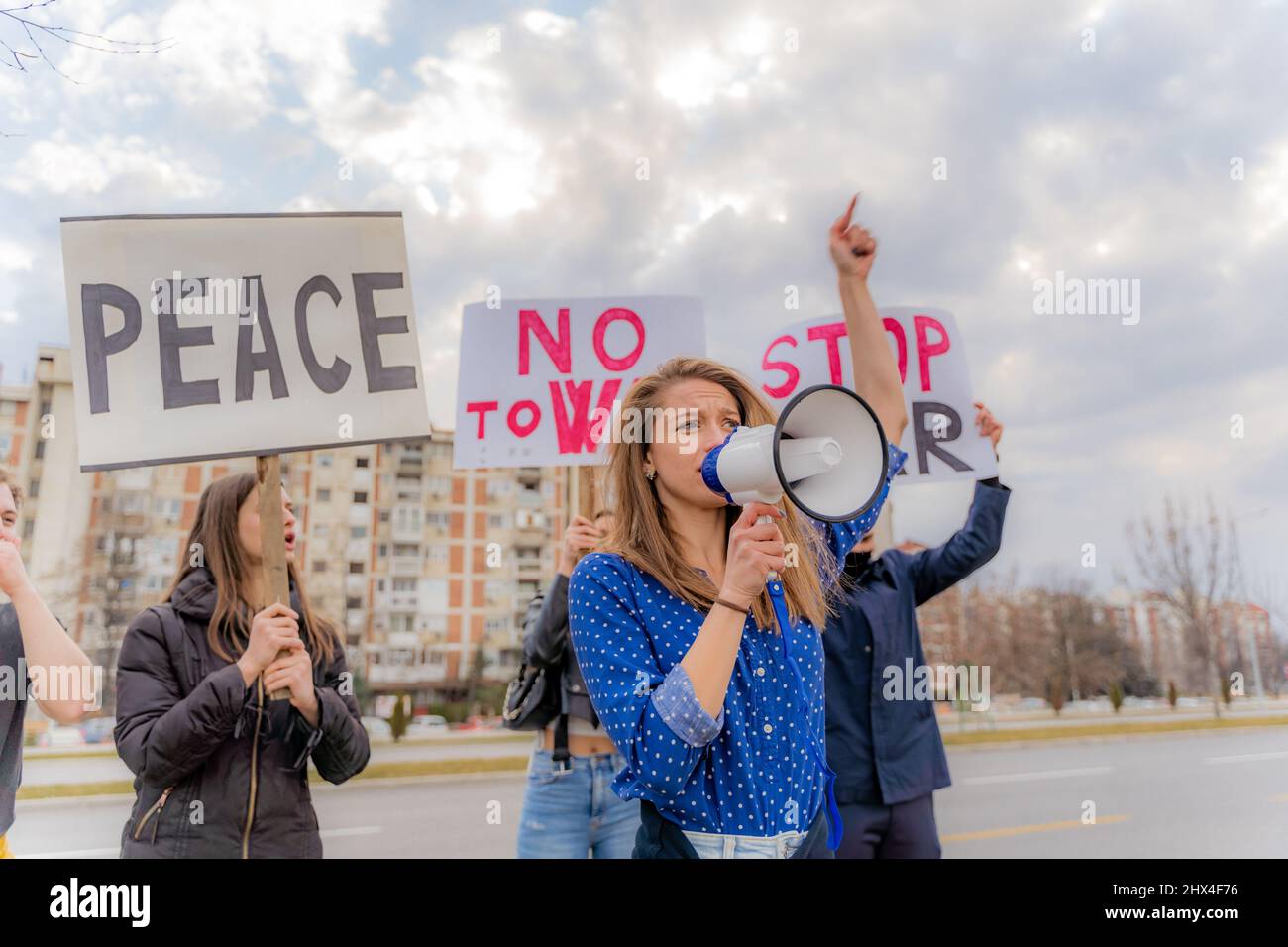 Beautiful and sad girl is shouting on the megaphone and protesting with ...