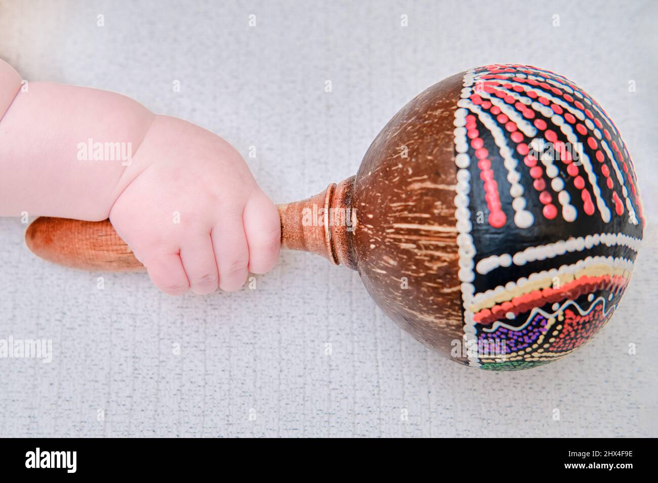 Baby hand and percussion musical instrument, close-up. Children fingers ...