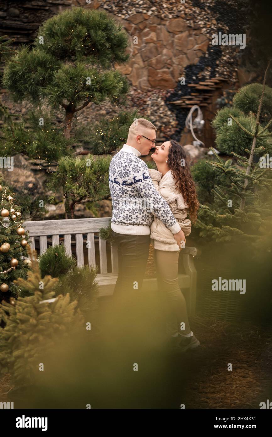 Christmas tree fir branches. Young couple decorating a Christmas tree ...
