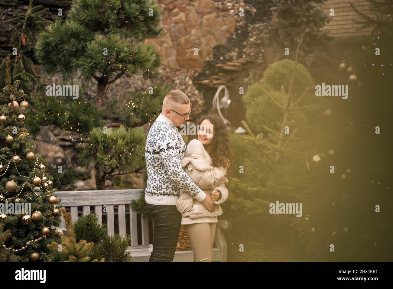 Christmas tree fir branches. Young couple decorating a Christmas tree ...