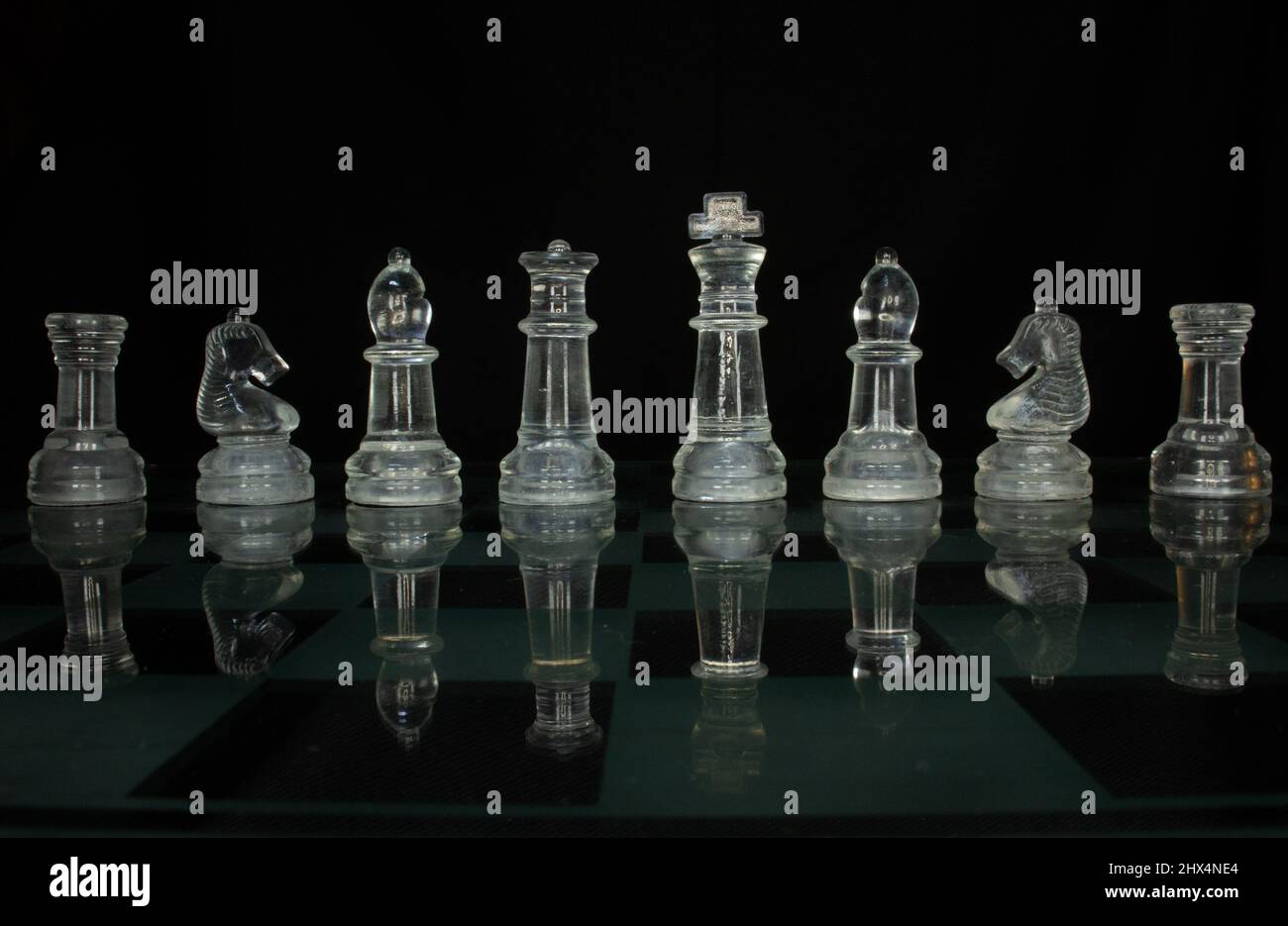 full set of eight clear chess piece isolated on a chequered chess board ...
