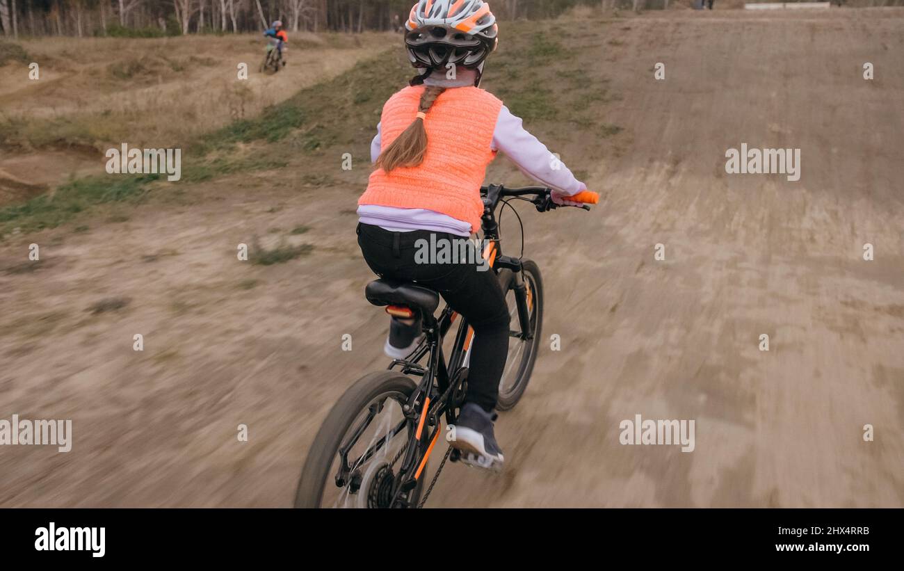One caucasian children rides bike road track in dirt park. Girl riding ...