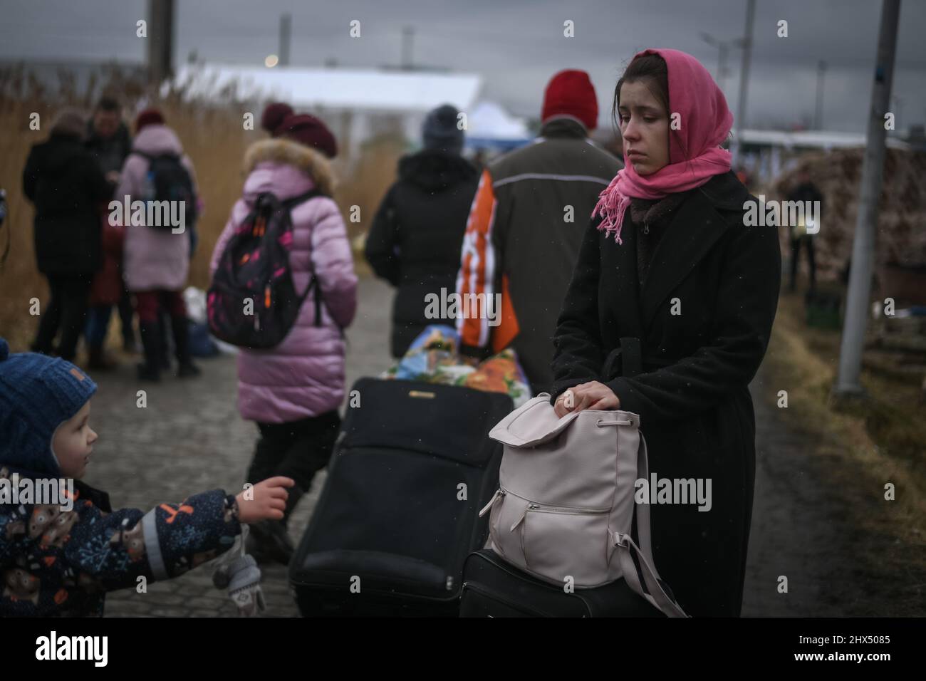 Medyka, Poland, March 9, 2022: a woman looks on as refugees from ...