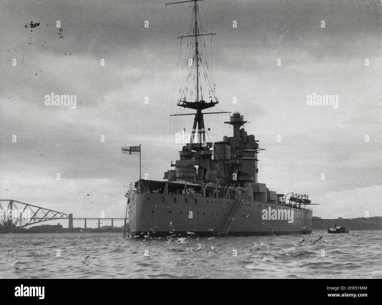 Fleet Anchors Under Forth Bridge -- H.M.S. Nelson with the Forth Bridge in background. Three of ...