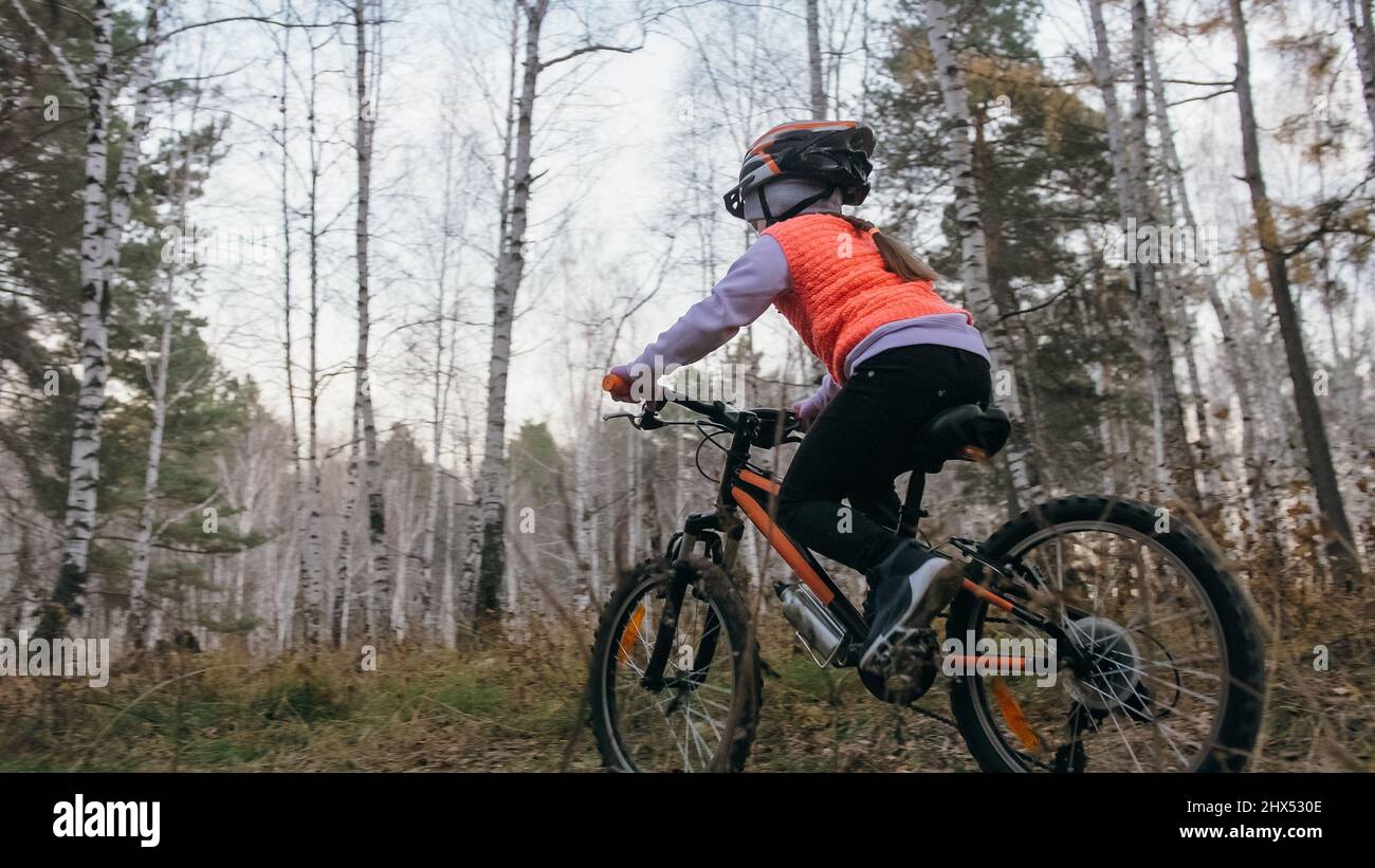 One caucasian children rides bike road in autumn park. Little girl ...