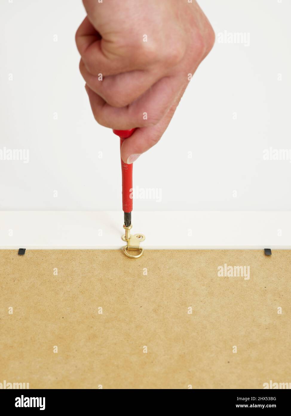 Hanging a picture frame, attaching ring and plate Stock Photo - Alamy