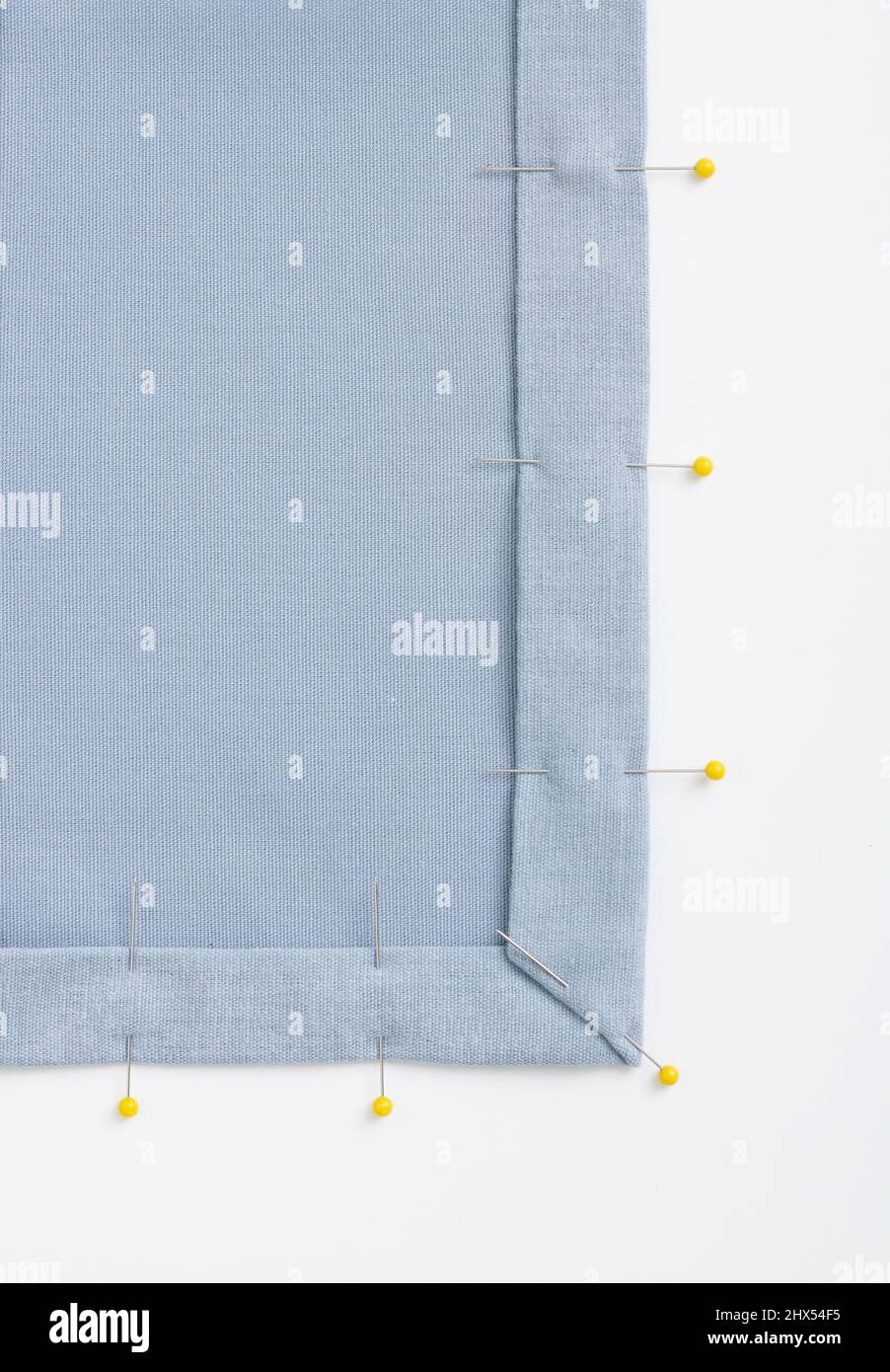 Folded and pinned edge of upholstery fabric Stock Photo - Alamy