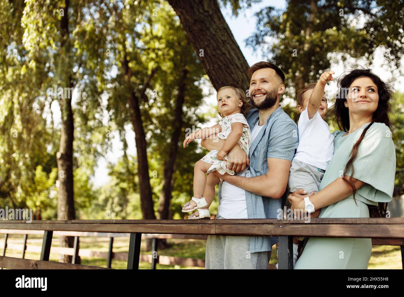 Happy family with little kids at the park, beautiful mother hold in ...