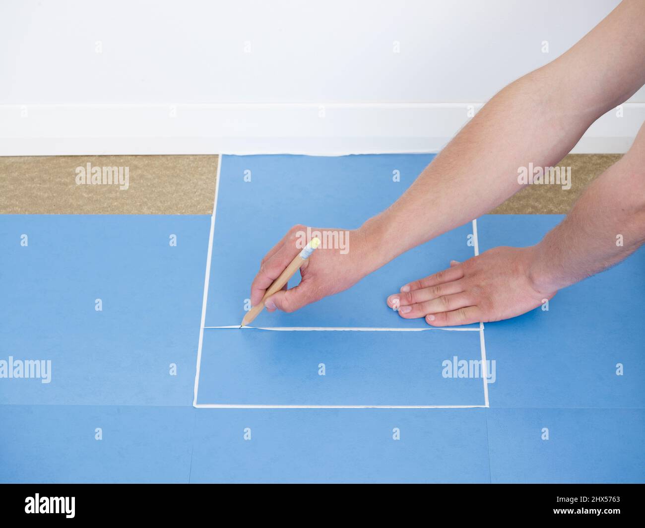 Laying vinyl tile floor, tiling the edge, marking the distance to the ...