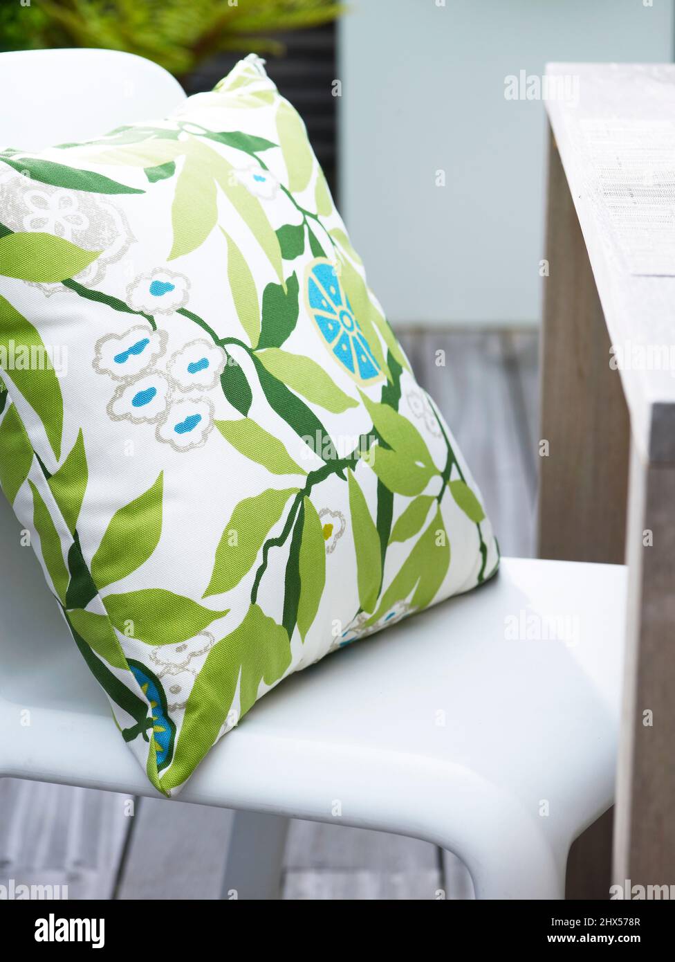 Leaf pattern cushion on chair on patio Stock Photo - Alamy